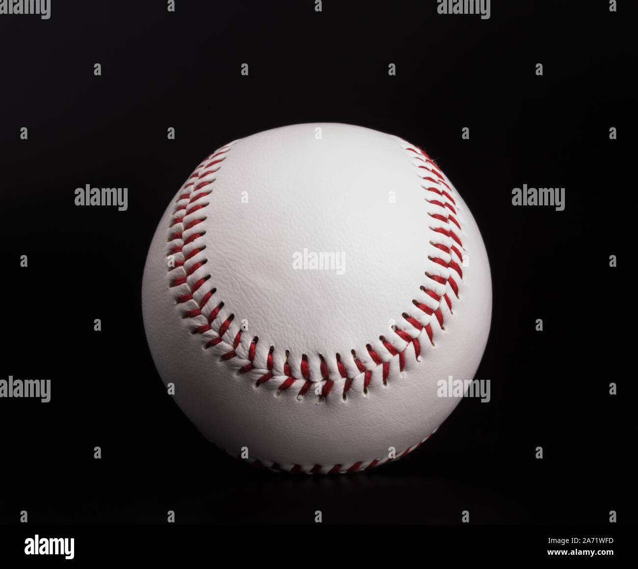 One new white baseball ball with red thread isolated on black ...