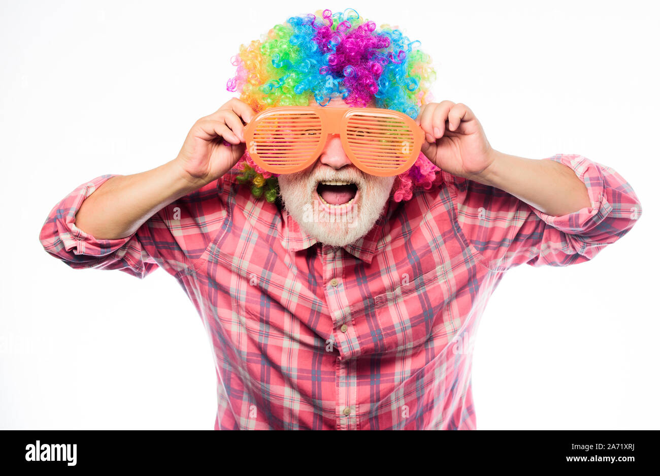 Man senior bearded cheerful person wear colorful wig and sunglasses. Elderly clown. Having fun ...