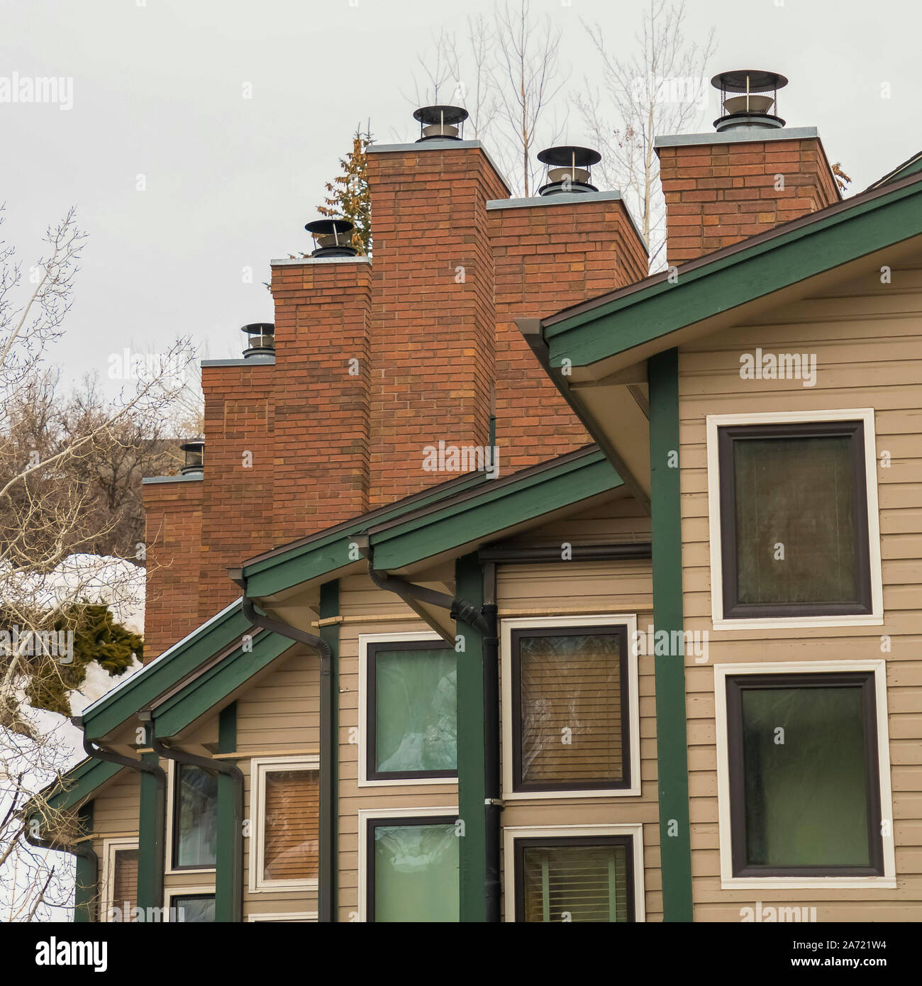 Square Townhomes with white exterior wall and red brick chimneys viewed ...