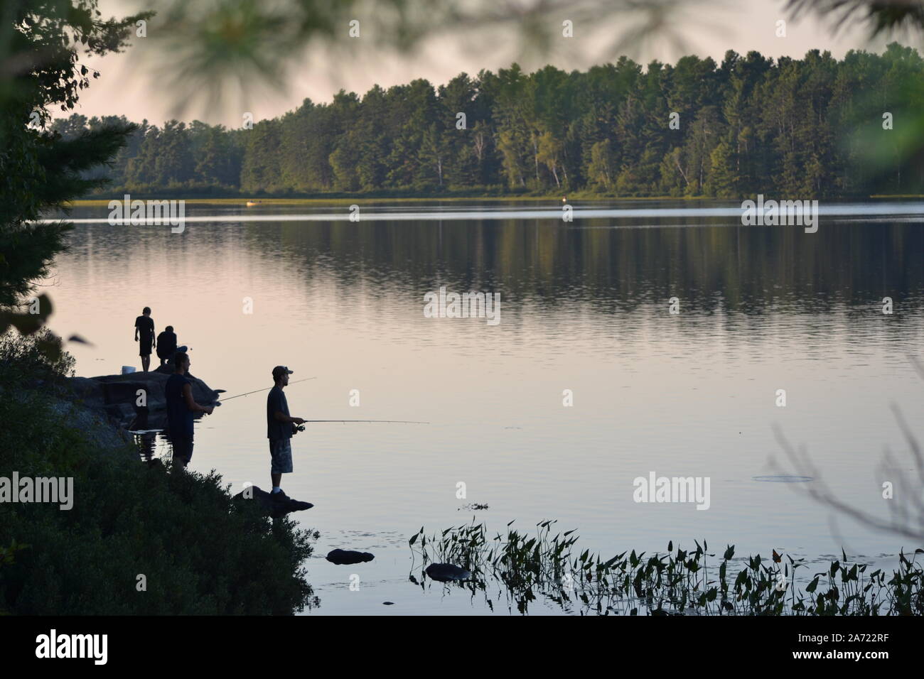Silhouette of people fishing at dusk Stock Photo - Alamy