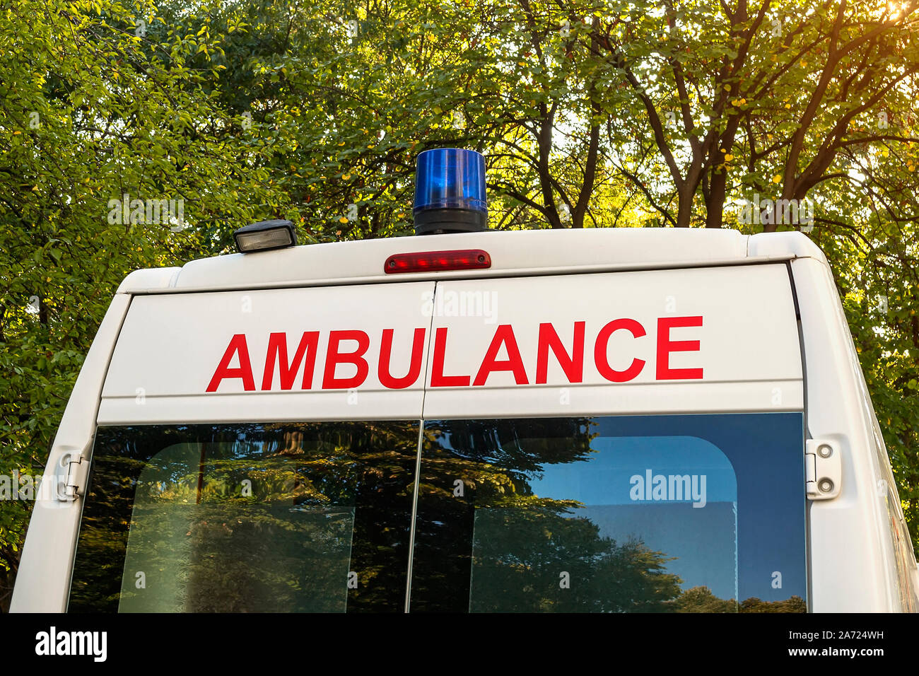 Stationary white ambulance car with a blue light on a roof. An ...