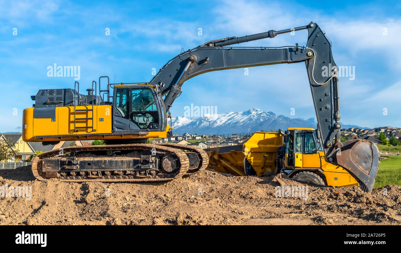 Panorama Excavator with metal arm and bucket and continuous tracks at a ...