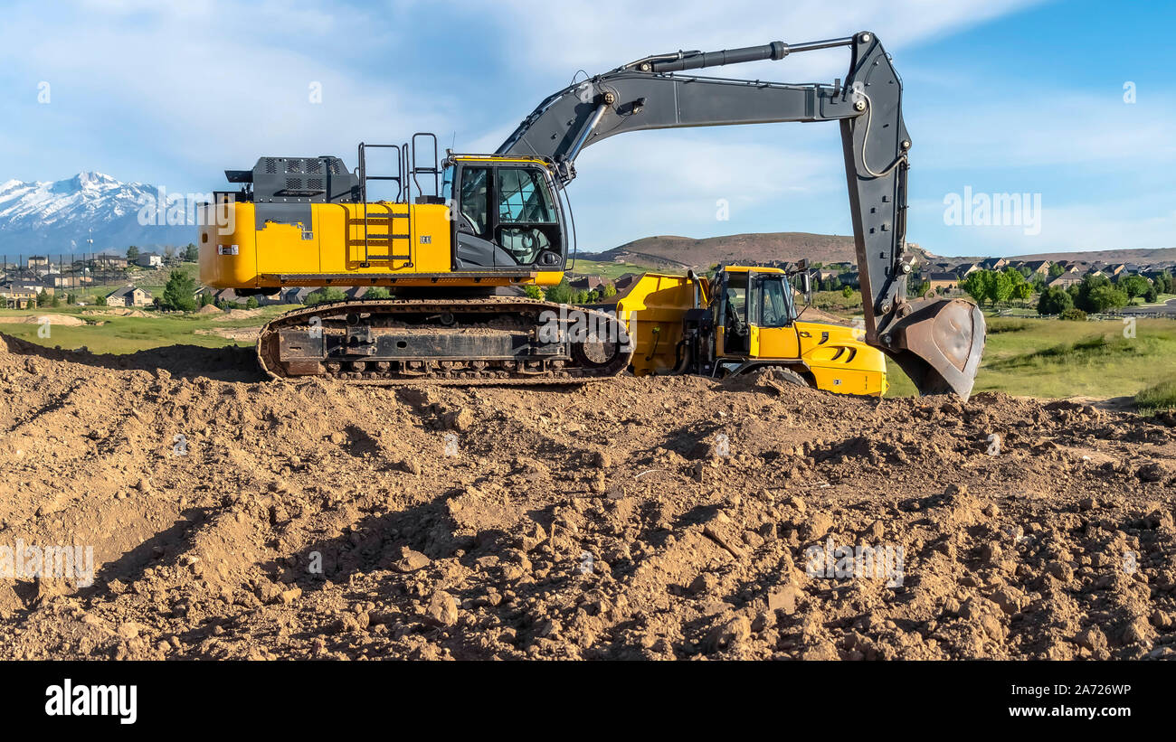 Panorama Yellow construction vehicles at a construction site against ...