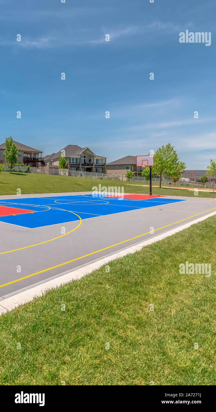 Vertical frame Basketball court pavilion and playground at a park under ...