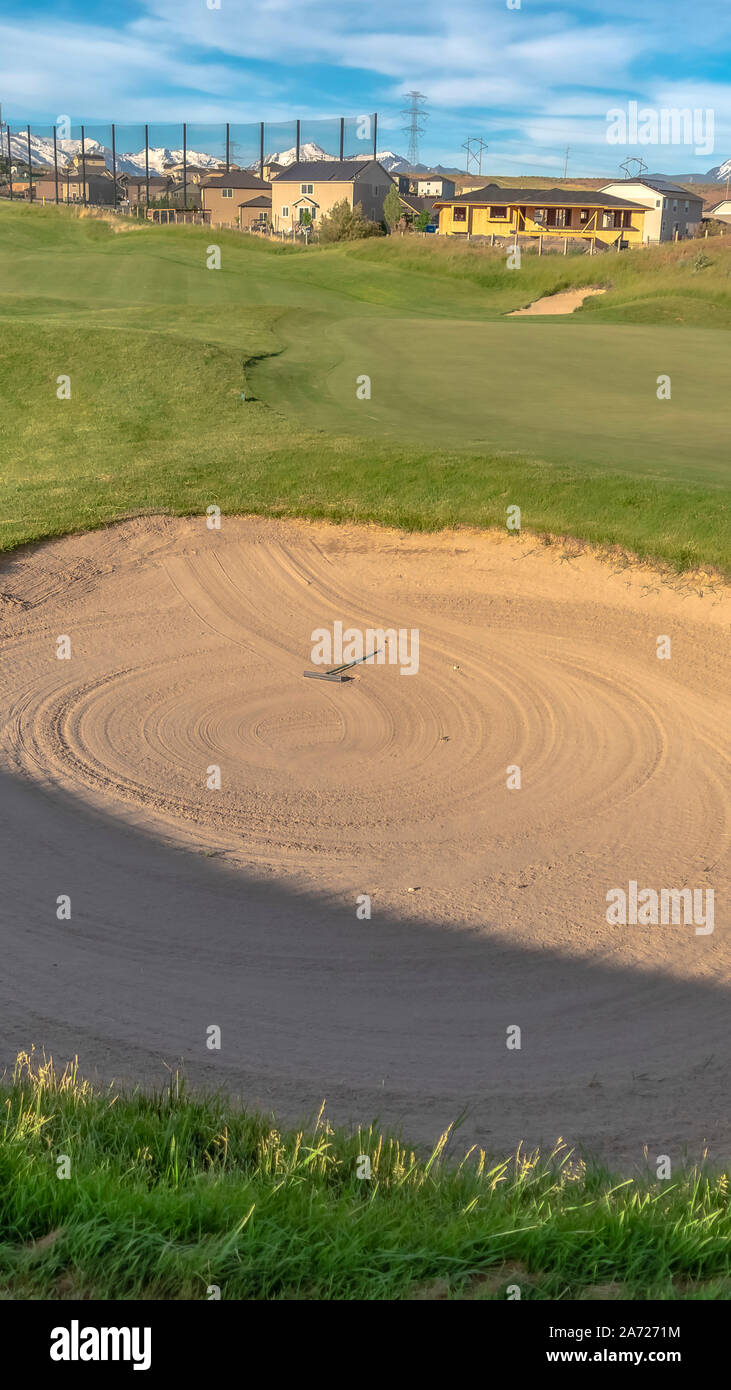 Vertical frame Close up view of a sand trap at a sunny golf course with ...