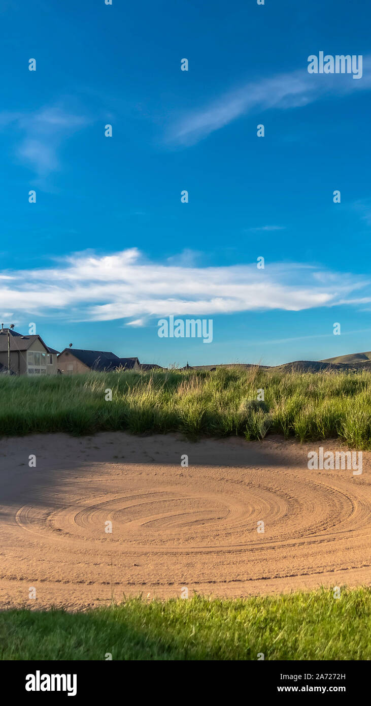 Vertical Close up of a sand trap or bunker surrounded by grasses at a ...