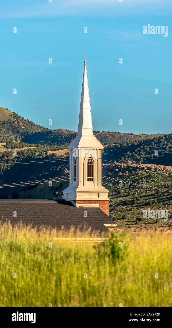 Vertical frame Rooftop and steeple of a church with mountain and pale ...