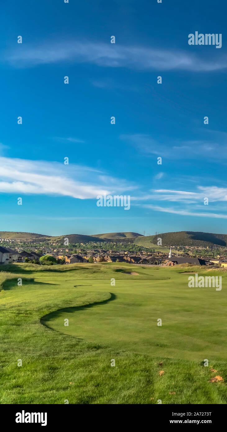 Vertical frame Golf course and houses with view of mountain towering in ...