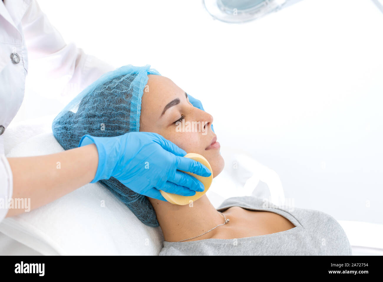 A woman, a professional doctor, a beautician cleanses the patient's ...