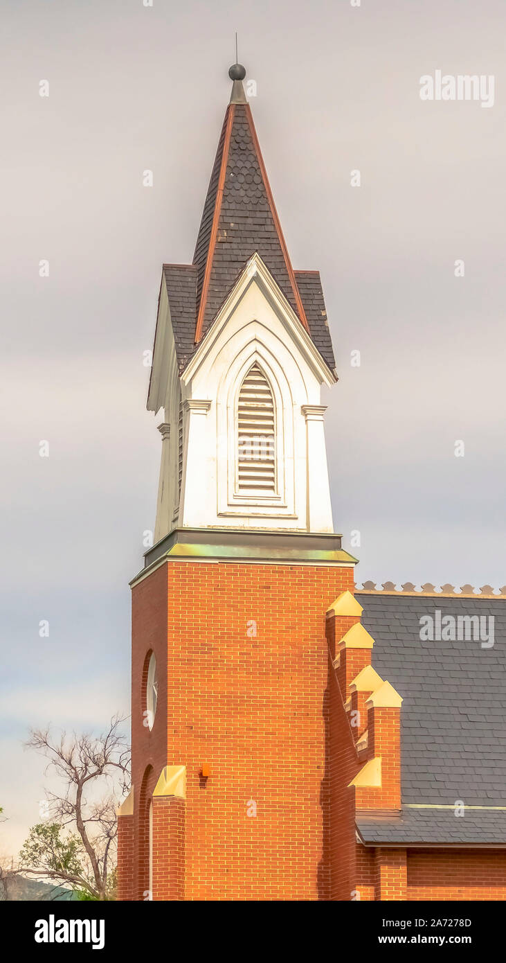 Vertical frame Side view of church exterior with focus on steeple and ...