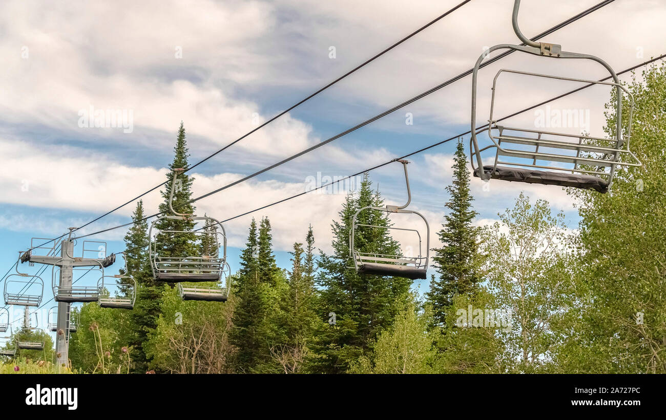 Panorama Chairlifts on cables with view of ski resort covered in ...