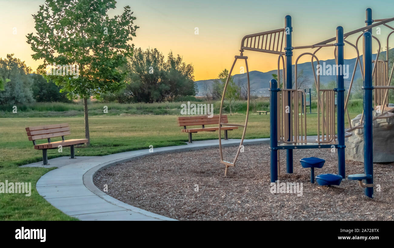 Panorama frame Playground and benches at a park against trees mountain ...