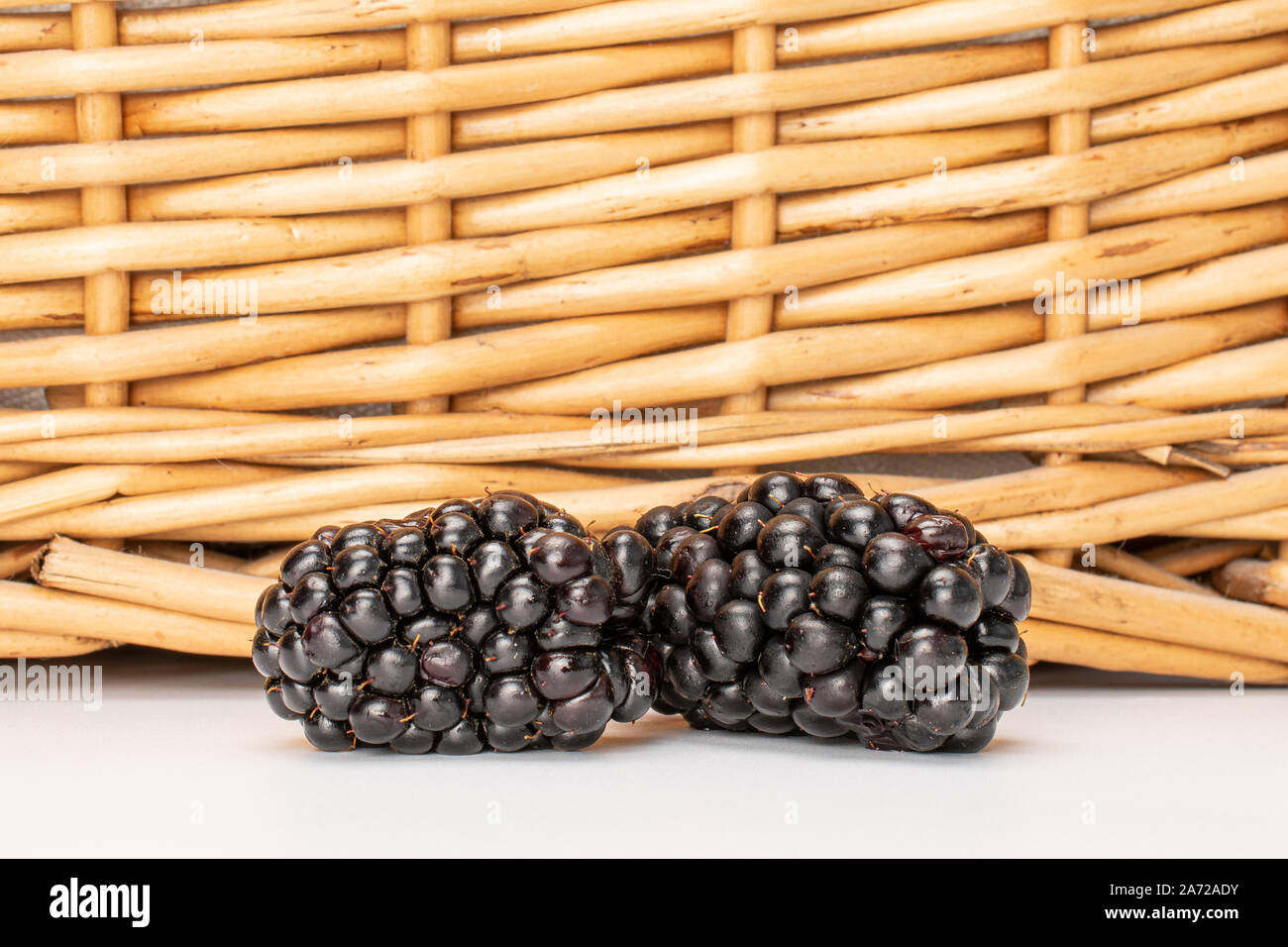 Group of two whole blackberries with braided twigs behind isolated on ...