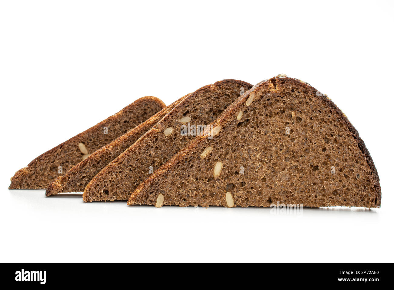 Group of four slices of fresh baked dark bread in row isolated on white ...