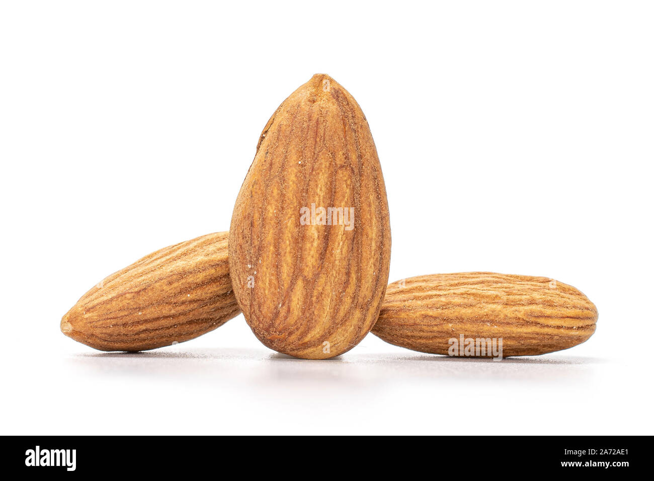 Group of three whole peeled almond nuts isolated on white background ...