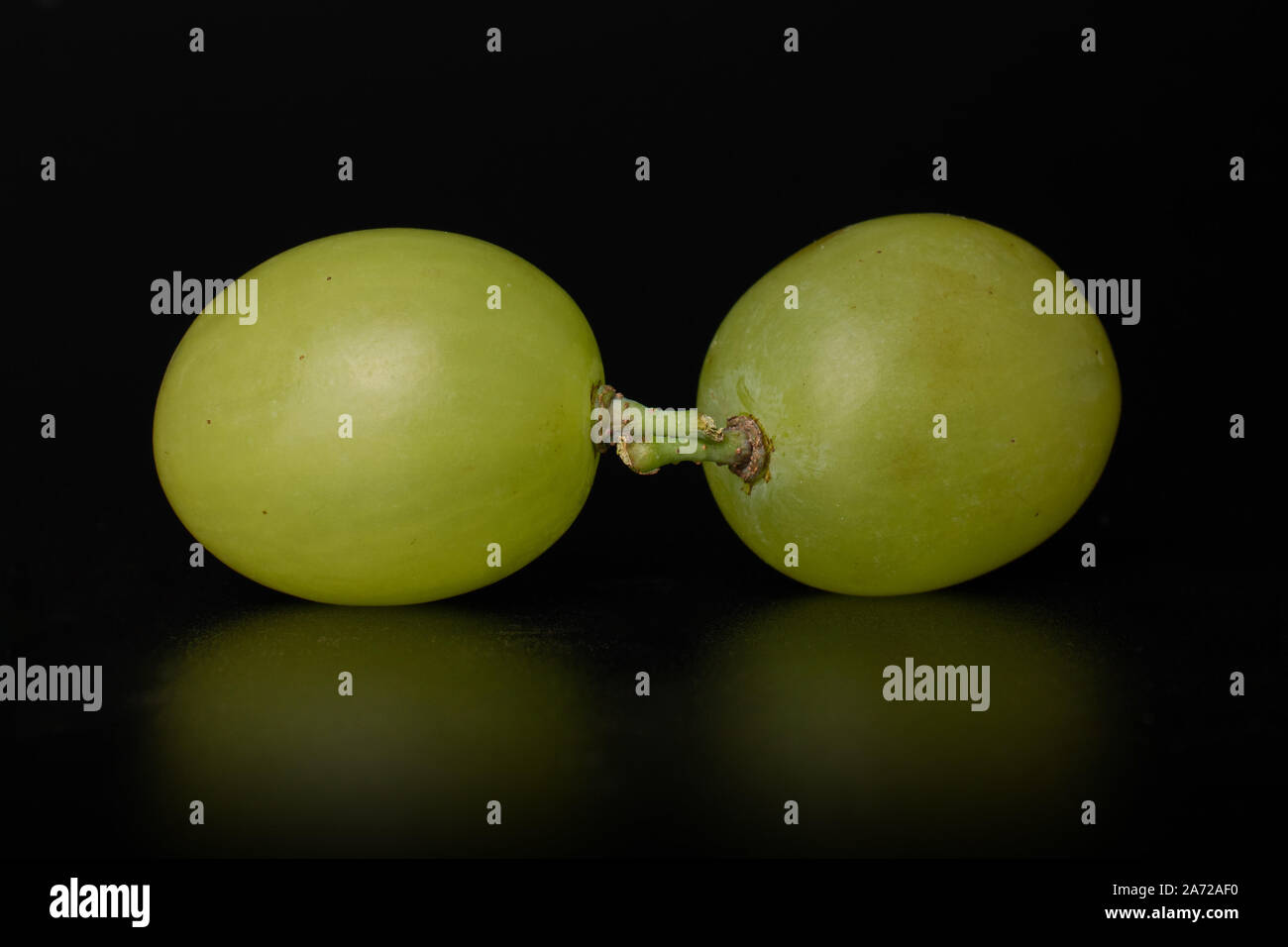 Group of two whole green table grapes isolated on black glass Stock ...