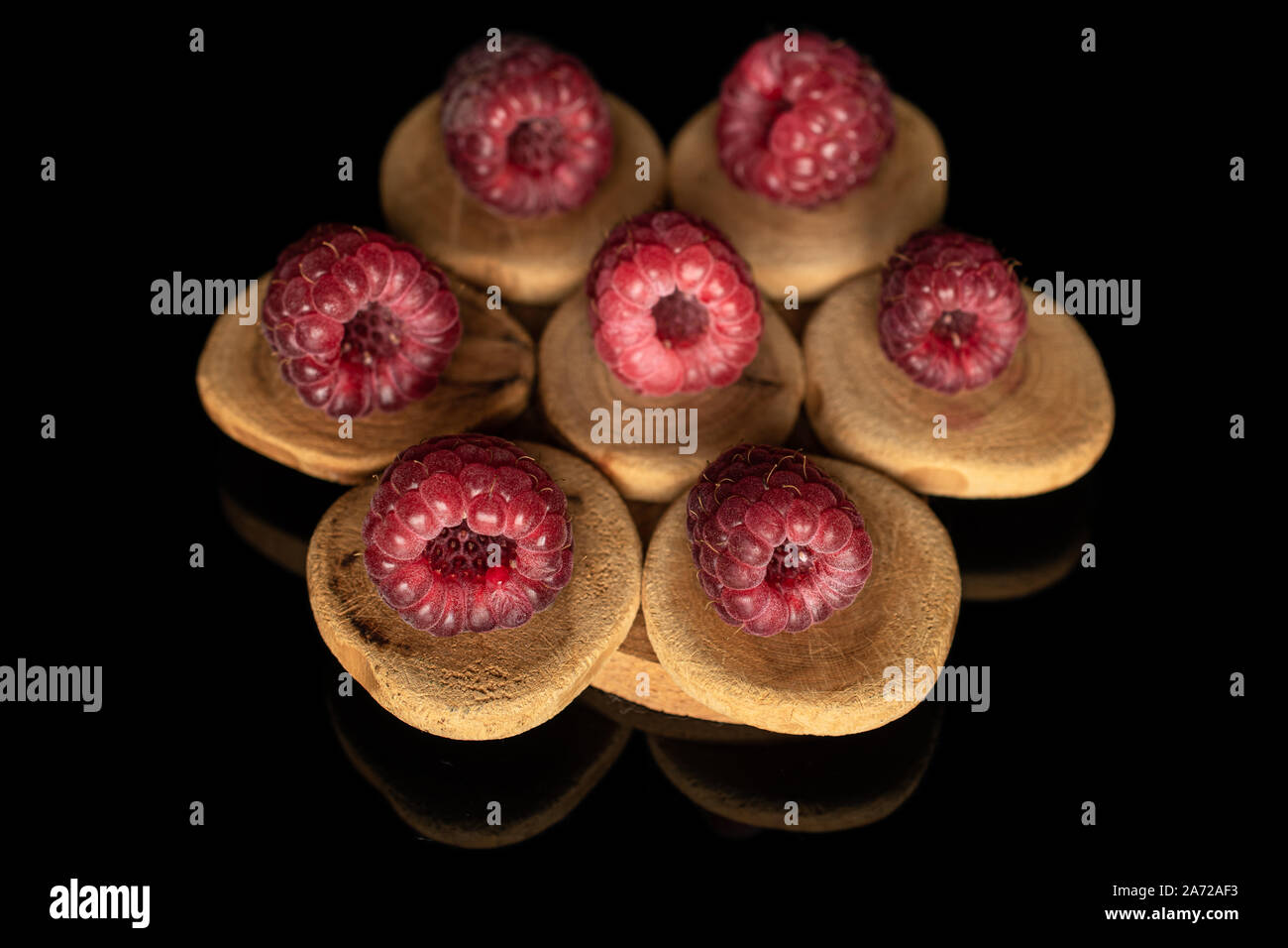 Group of seven whole fresh crimson raspberry on tree stump isolated on ...