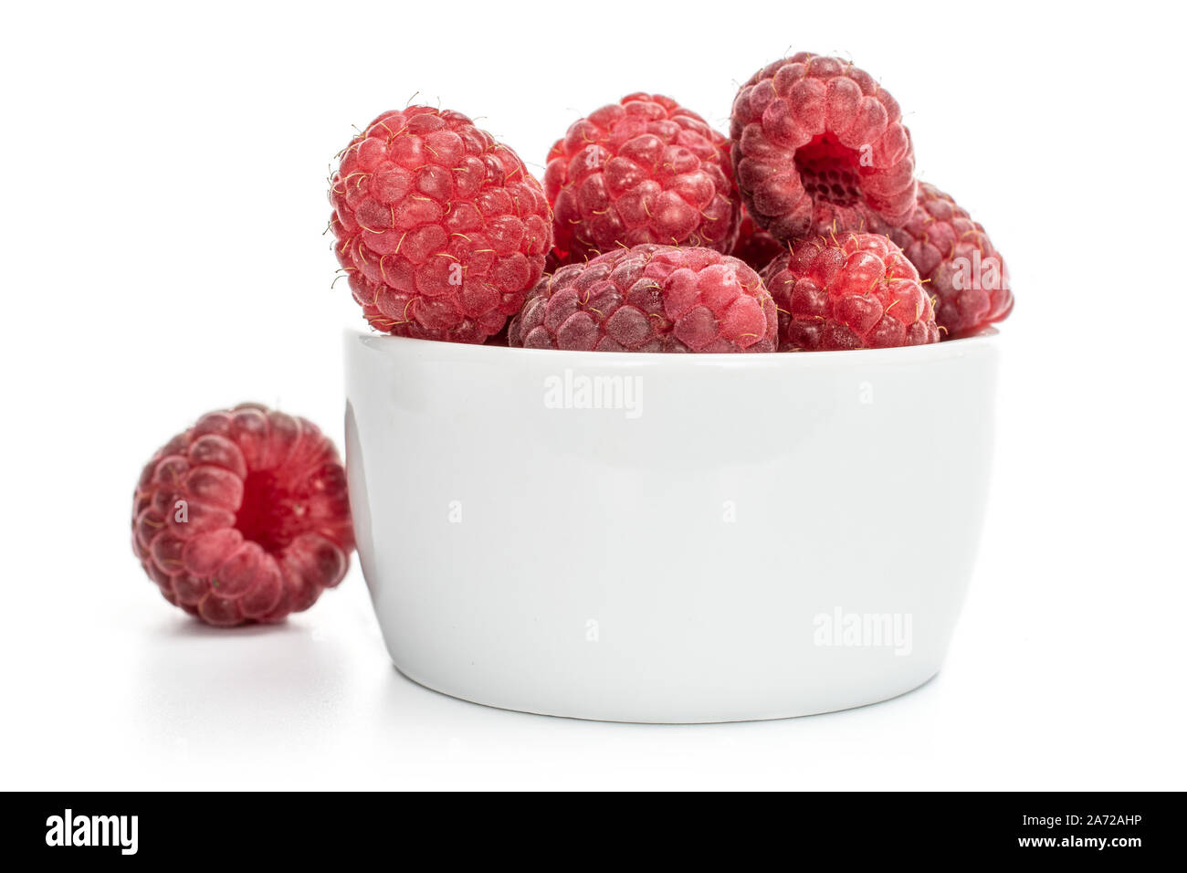 Lot of whole fresh crimson raspberry in white sauce bowl isolated on ...