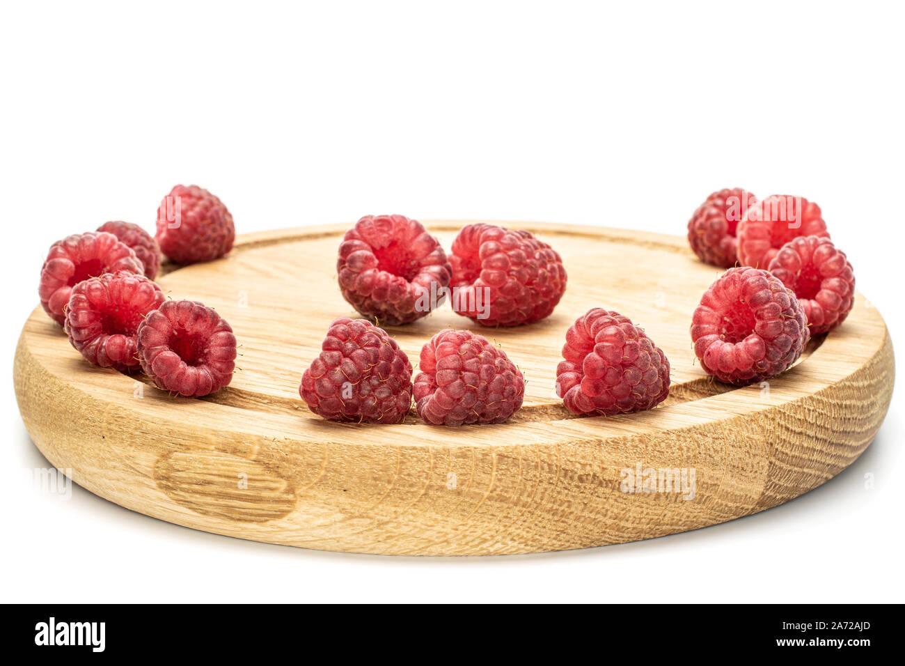 Group of six whole fresh crimson raspberry on grey stone isolated on ...