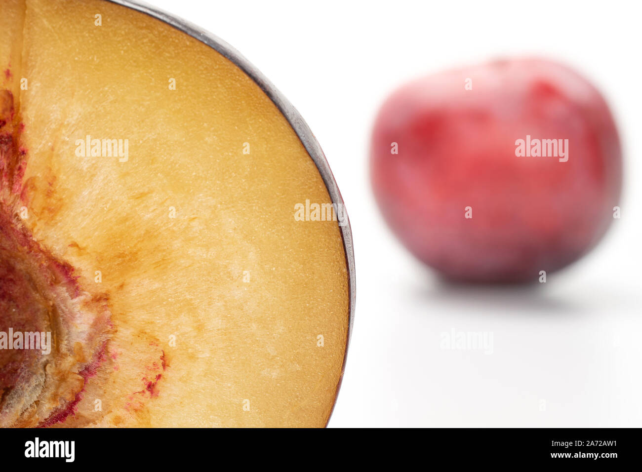 Group of one whole one half of fresh red plum closeup isolated on white ...