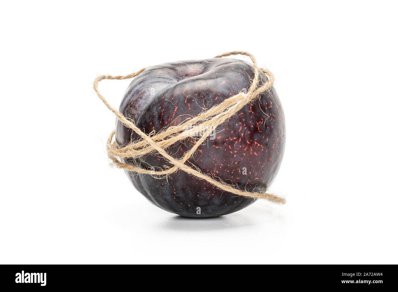 One whole fresh red plum tied by jute thread isolated on white ...