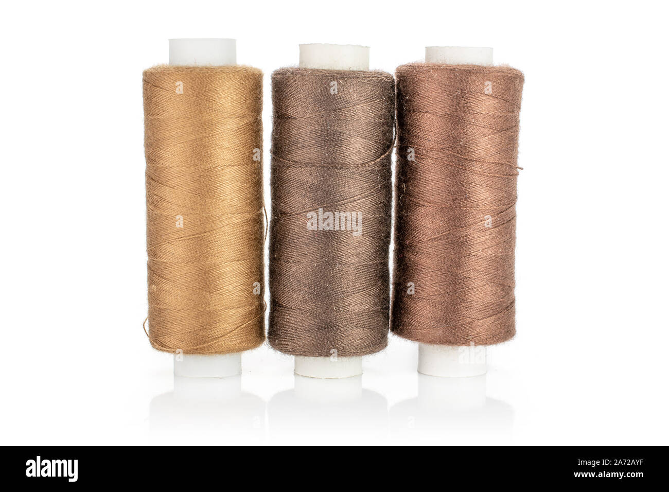Group of three whole haberdashery item standing thread spools isolated ...