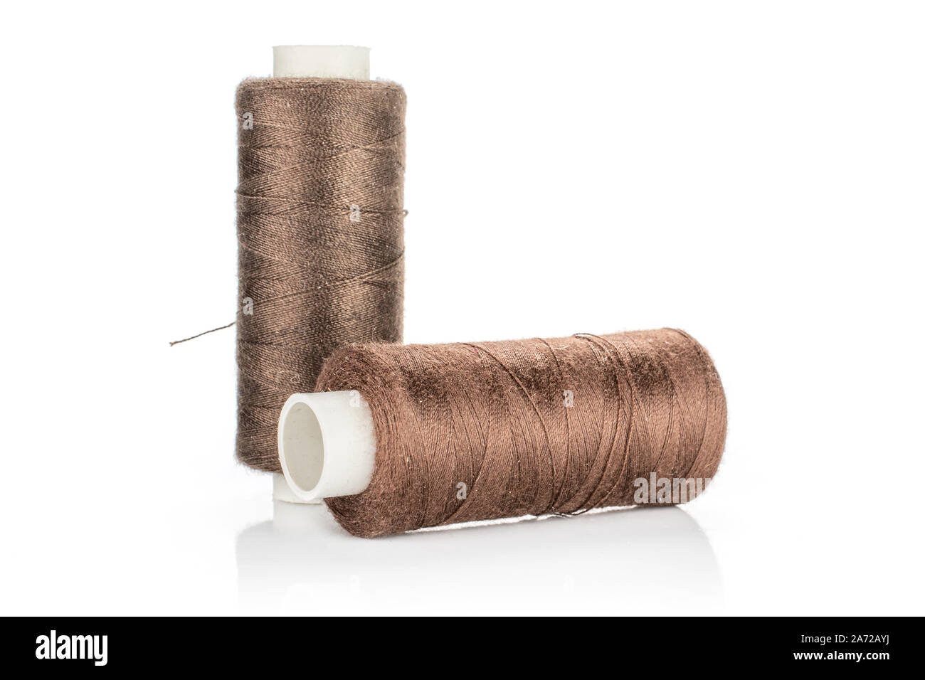 Group of two whole haberdashery item brown thread spools isolated on ...