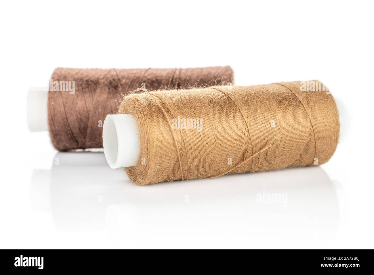 Group of two whole haberdashery item brown thread spools isolated on ...