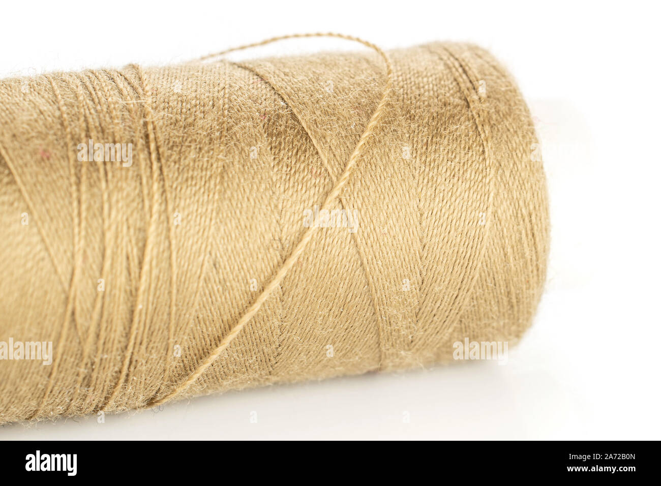 One whole haberdashery item beige thread spool macro isolated on white ...