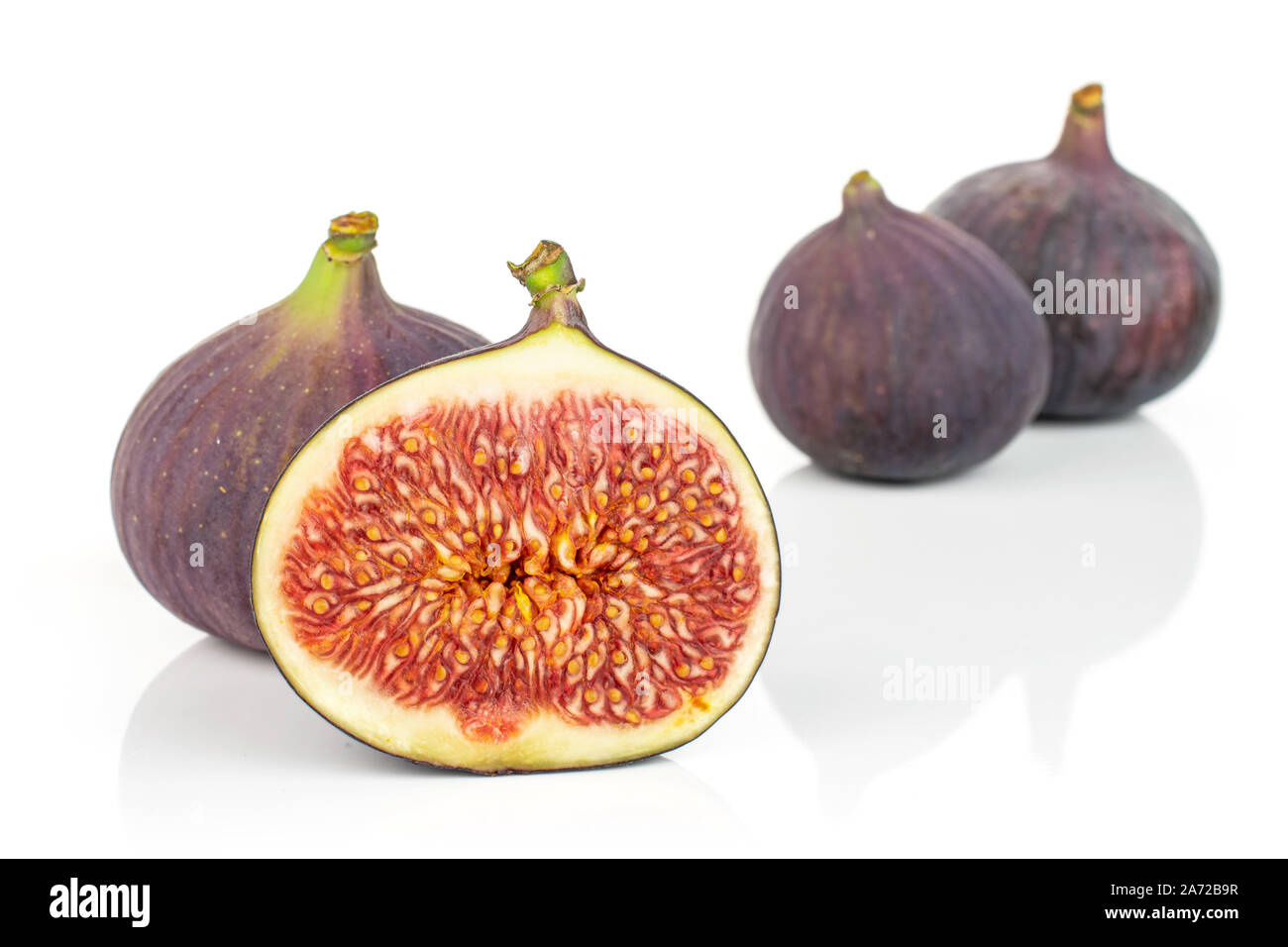 Group of three whole one half of fresh purple fig isolated on white ...