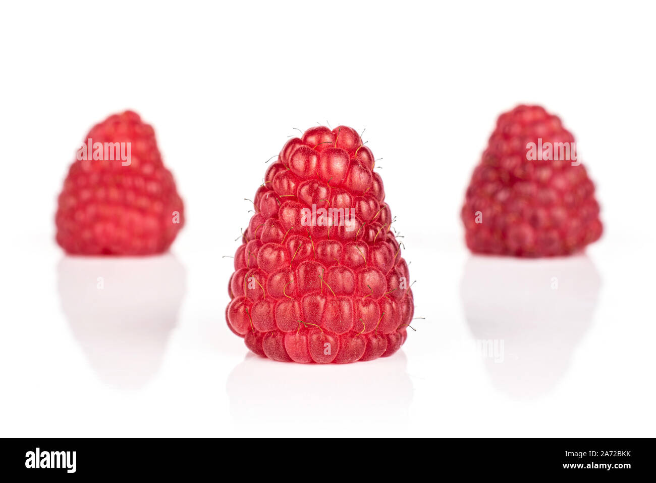 Group of three whole fresh red raspberry isolated on white background ...
