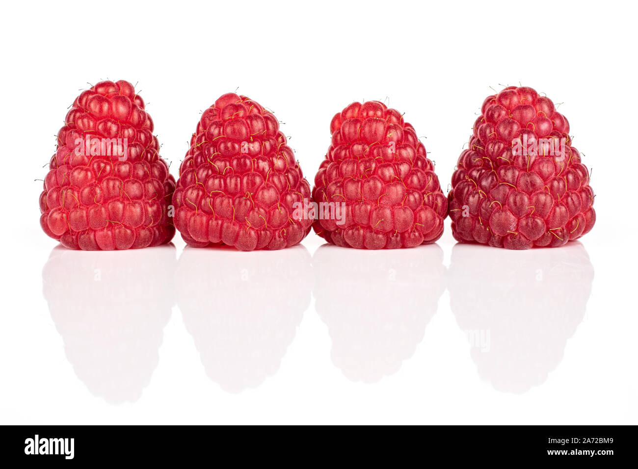 Group of four whole fresh red raspberry isolated on white background ...