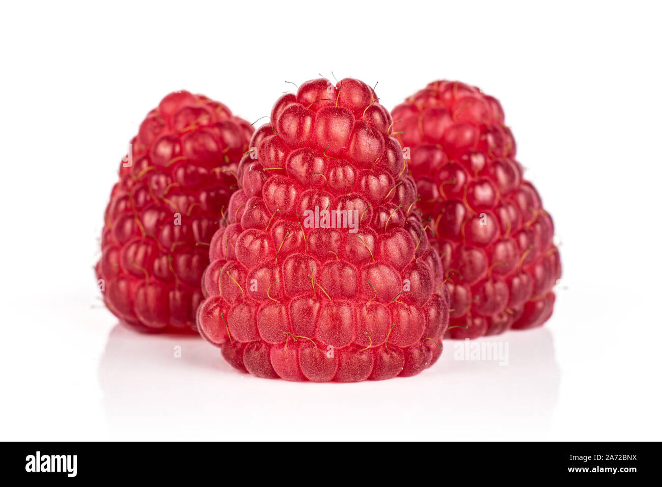 Group of three whole fresh red raspberry isolated on white background ...