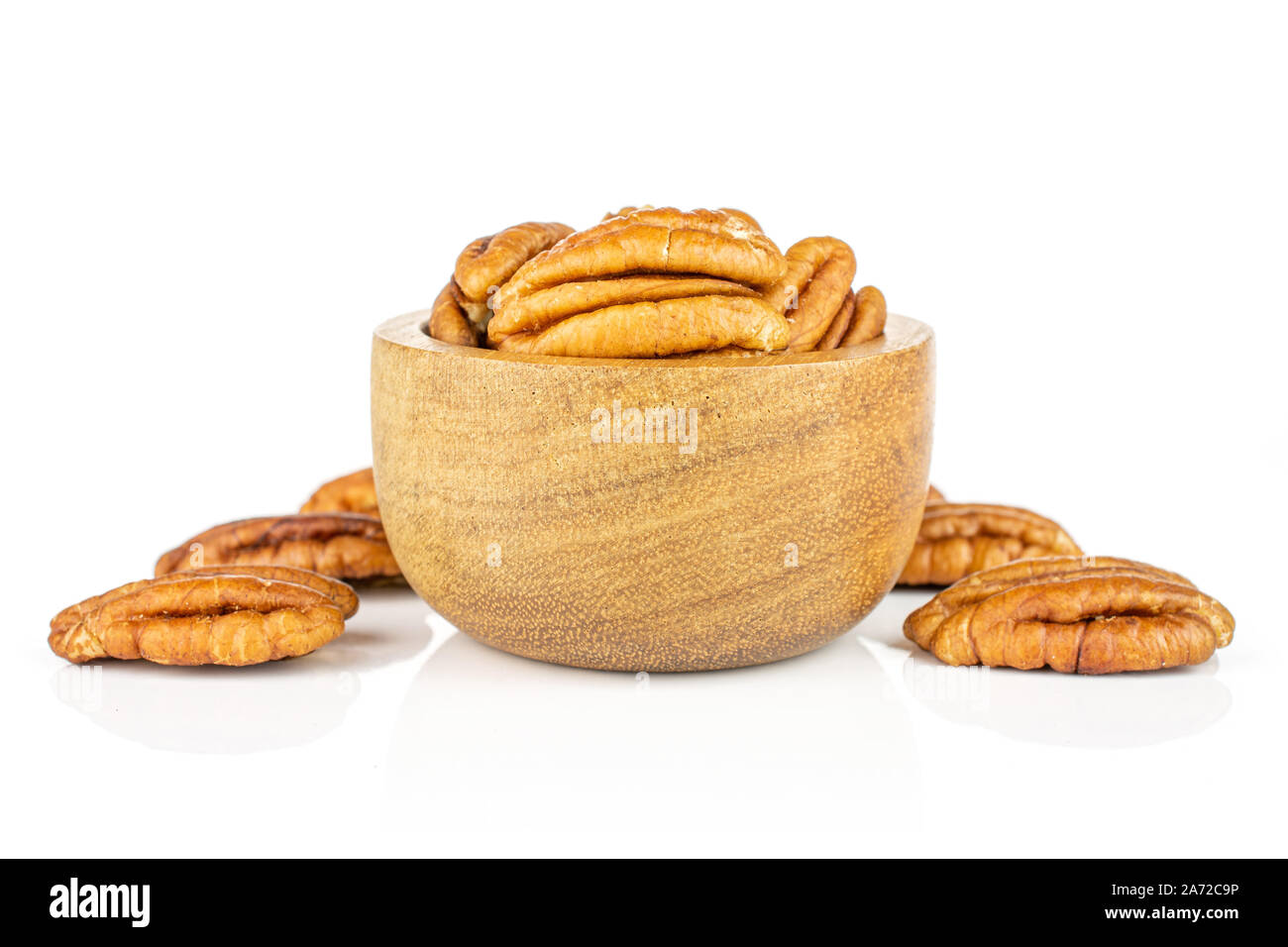 Lot of whole dry brown pecan nut in tiny wooden bowl isolated on white ...