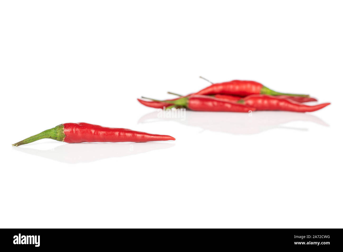 Lot of whole hot red chili front focus isolated on white background ...