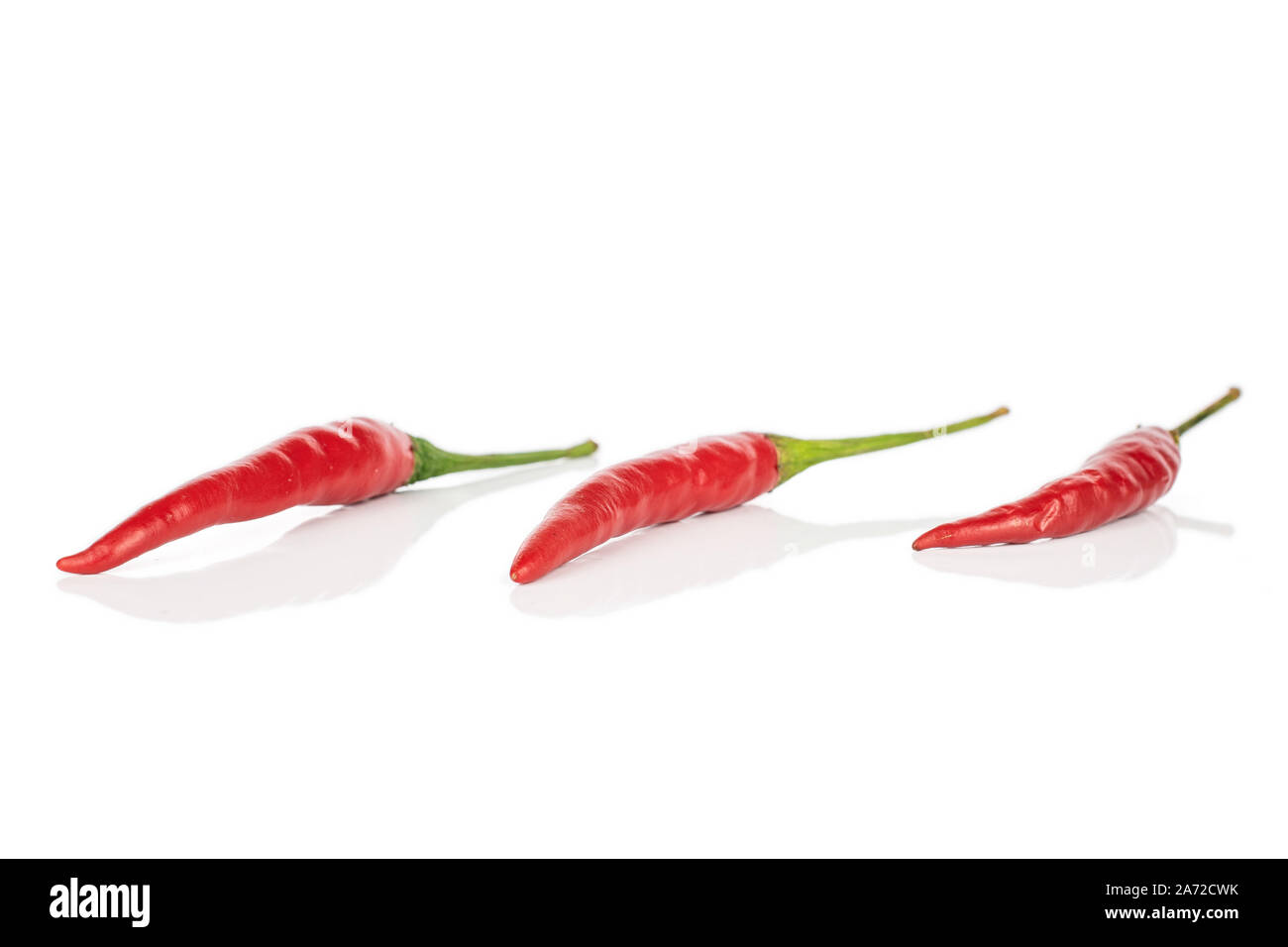 Group of three whole hot red chili in line isolated on white background ...