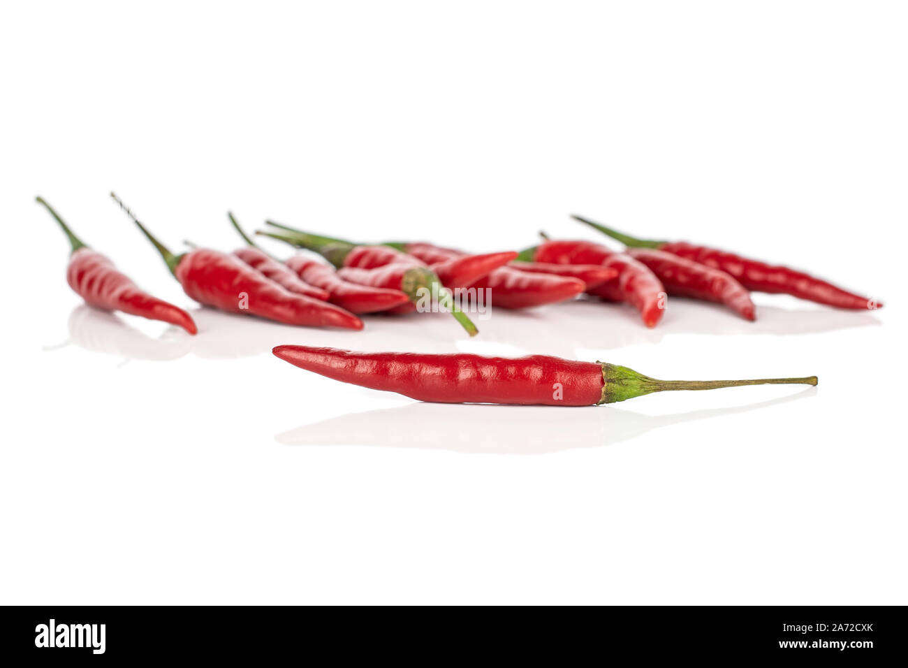 Lot of whole hot red chili front focus isolated on white background ...