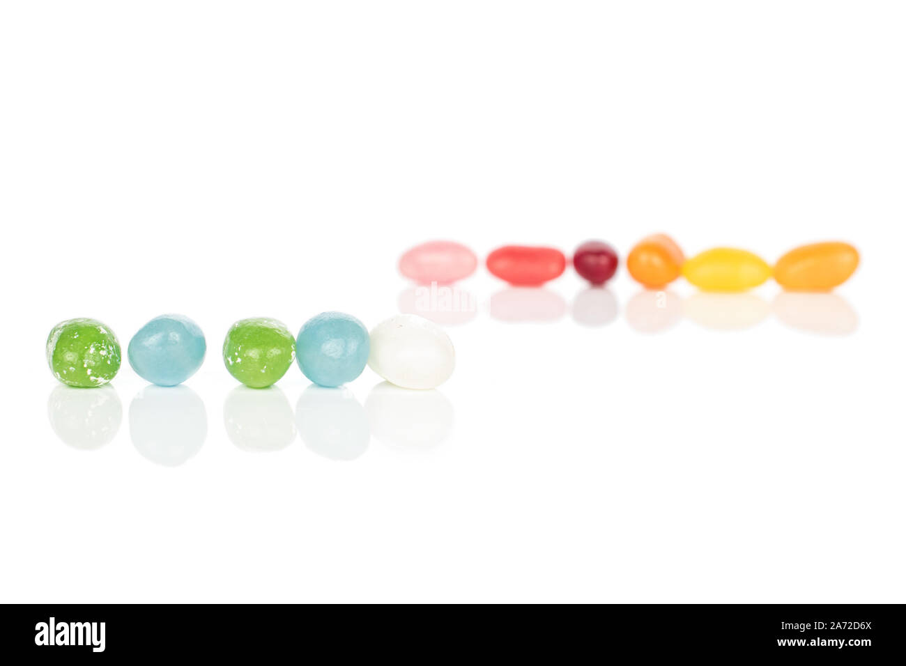 Lot of whole jelly bean candy in two lines isolated on white background ...