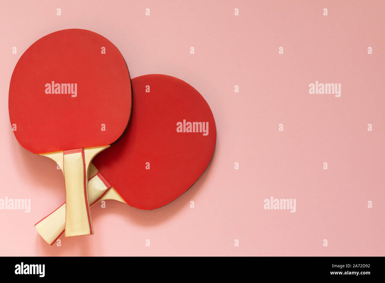 Red tennis ping pong rackets isolated on a pink background, sport ...