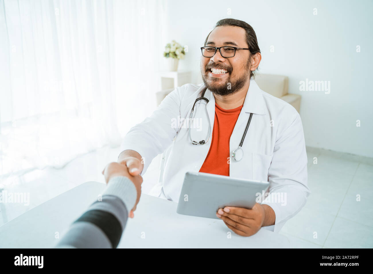 Doctor and patient shaking hands in modern hi-res stock photography and ...