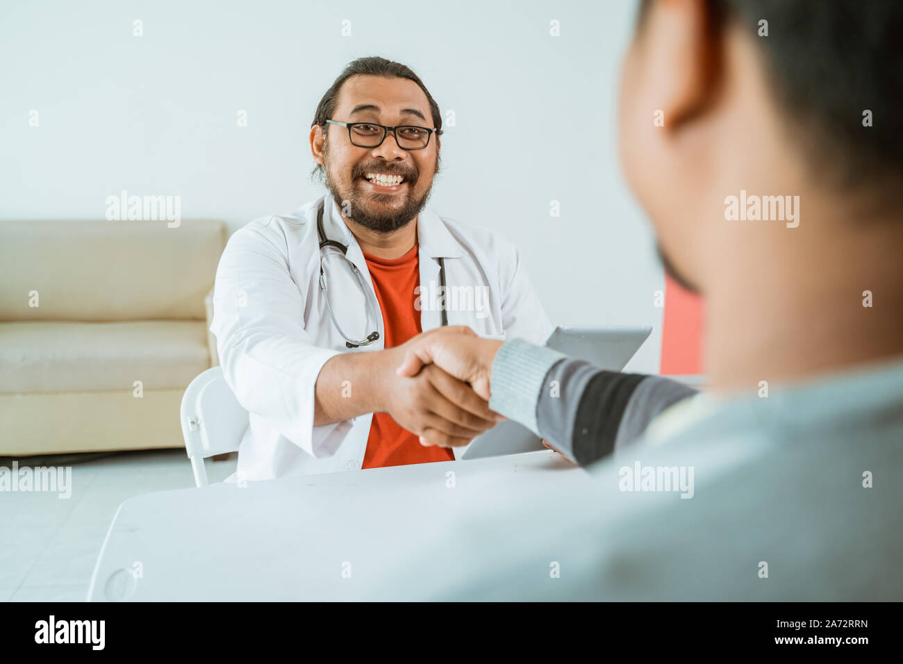 Male doctor tablet shaking hand hi-res stock photography and images - Alamy