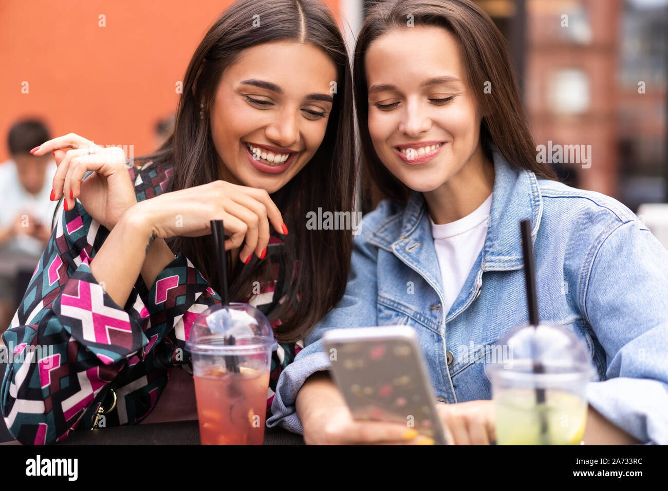 Young girls friends watch something in smartphone Stock Photo - Alamy