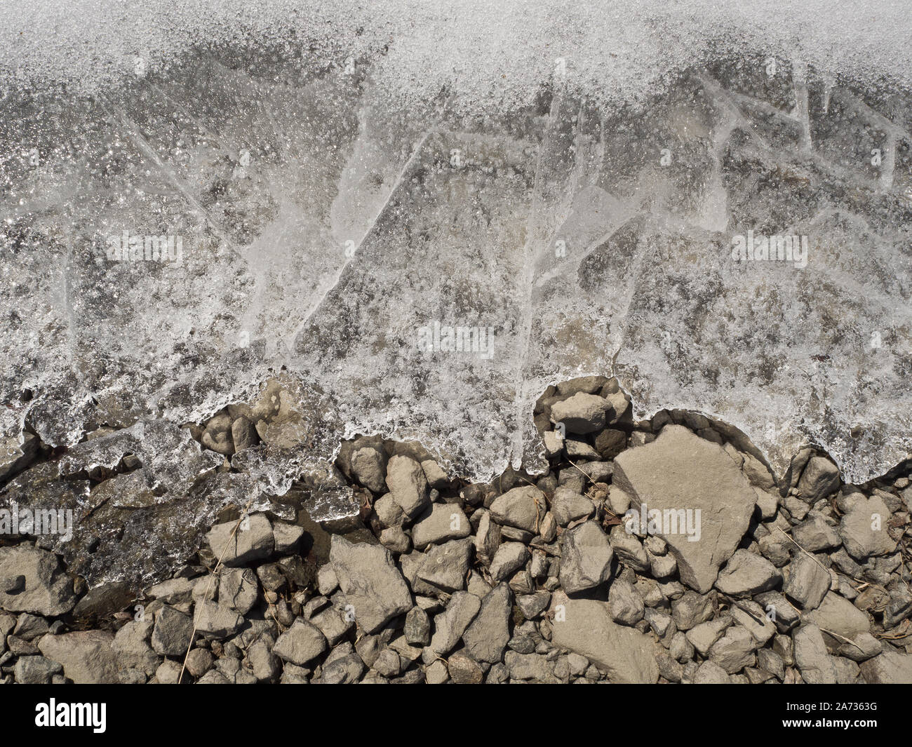 Ground texture. Ice layer over stones Stock Photo - Alamy