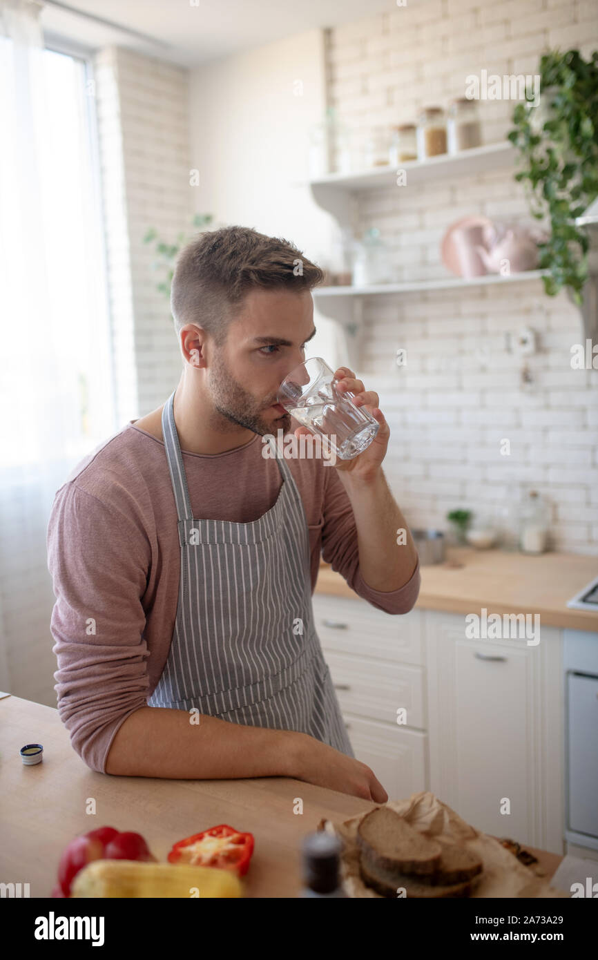Man standing in the kitchen and drinking water Stock Photo - Alamy