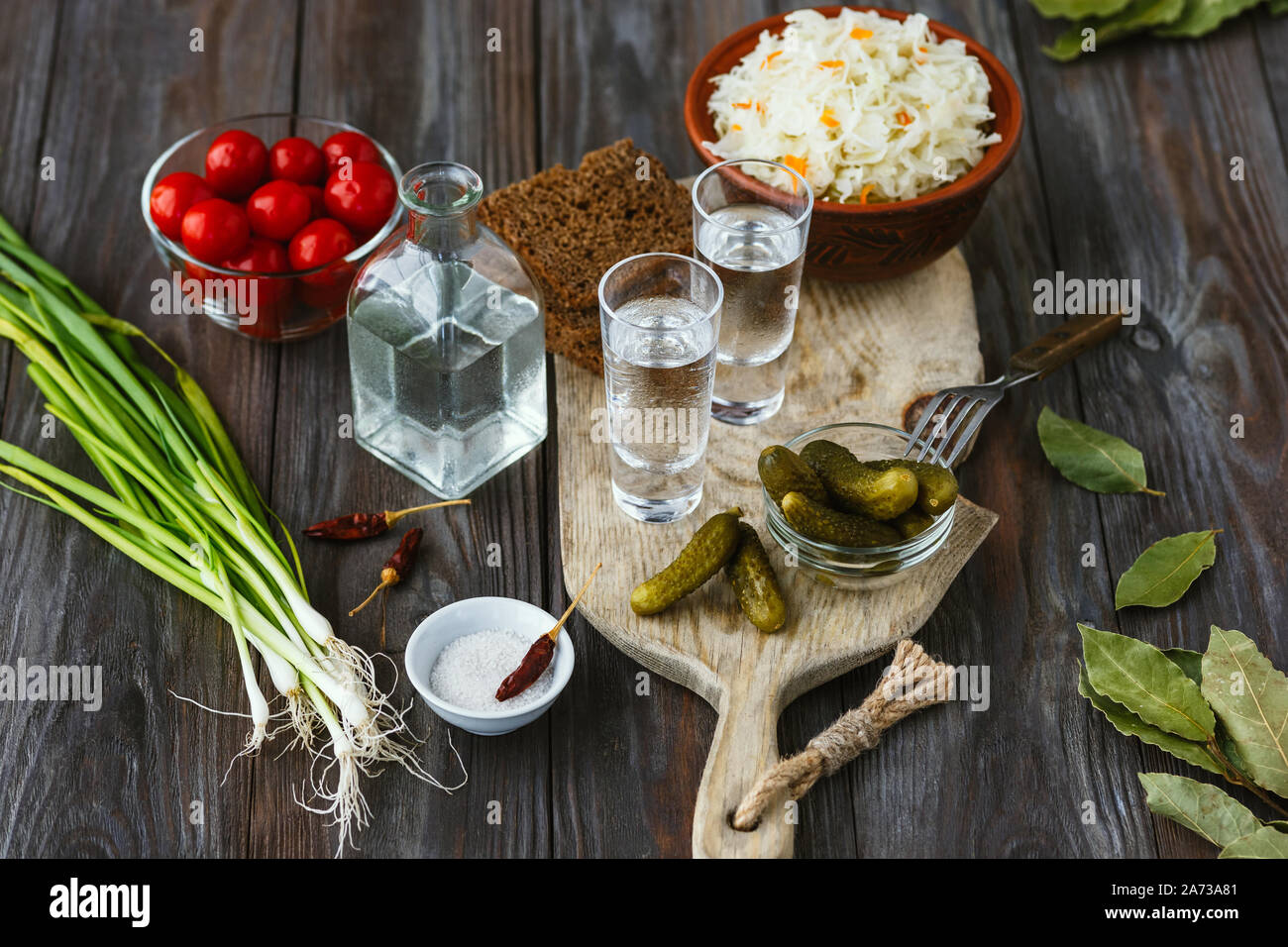 Vodka with salted vegetables on wooden background. Alcohol pure craft ...