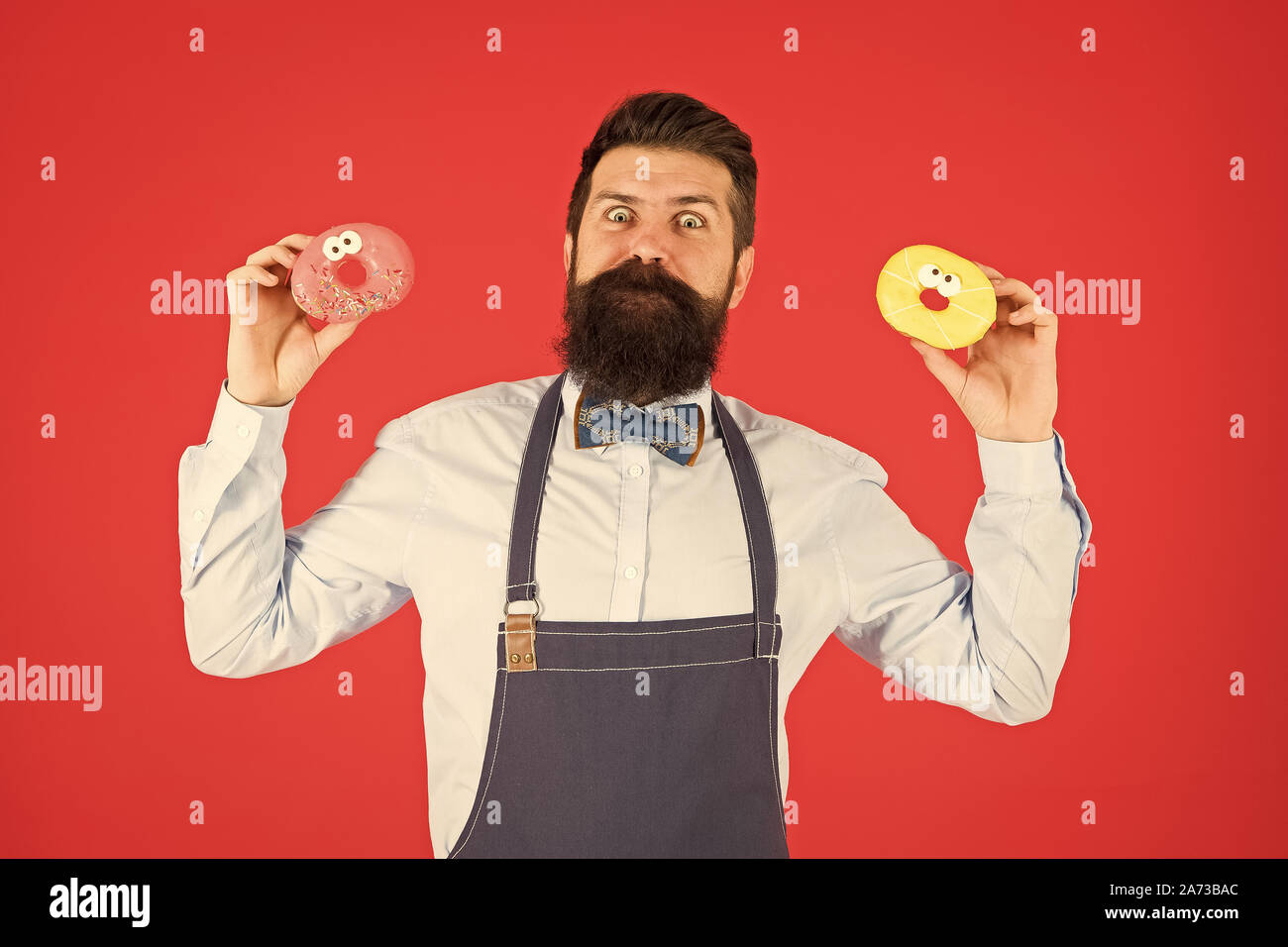Catering bakery products to you. Bearded man holding ring donuts in ...