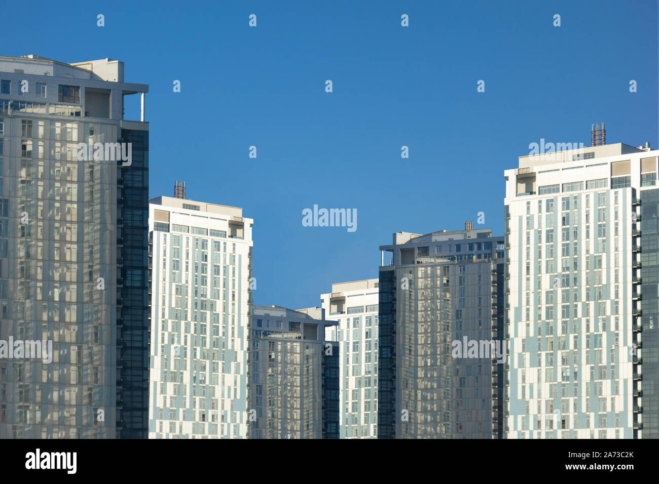Group of skyscrapers or flat block buildings on clear blue sky ...