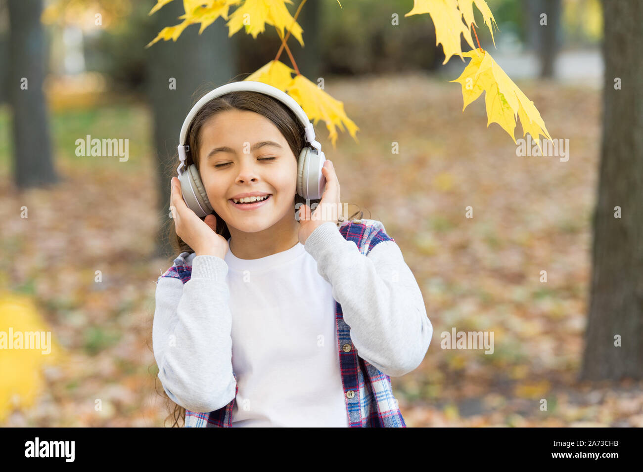 Best song about fall. Cute small child enjoy song playing in headphones ...