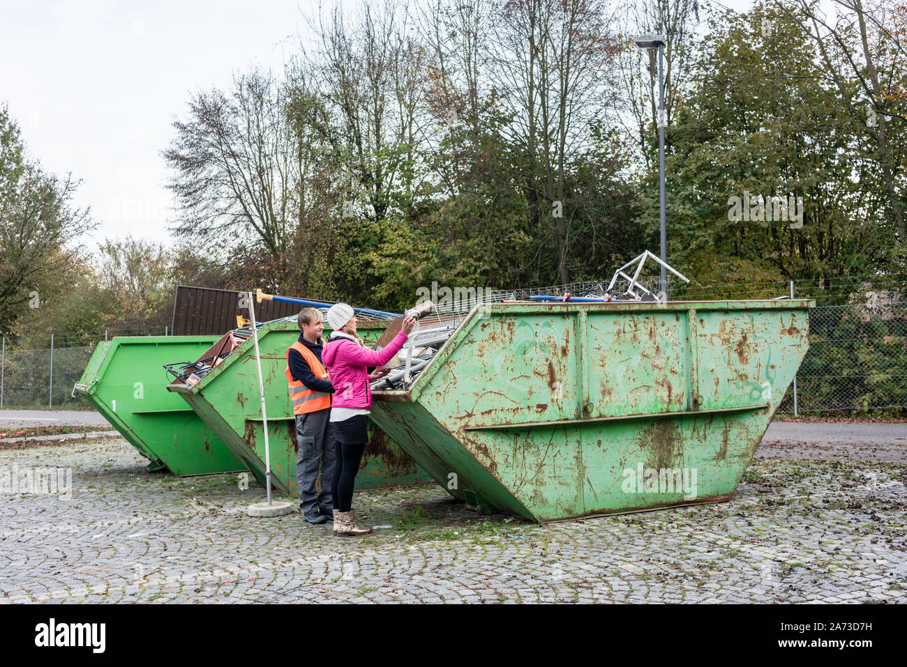 Woman putting scrap metal in container to be recycled Stock Photo - Alamy