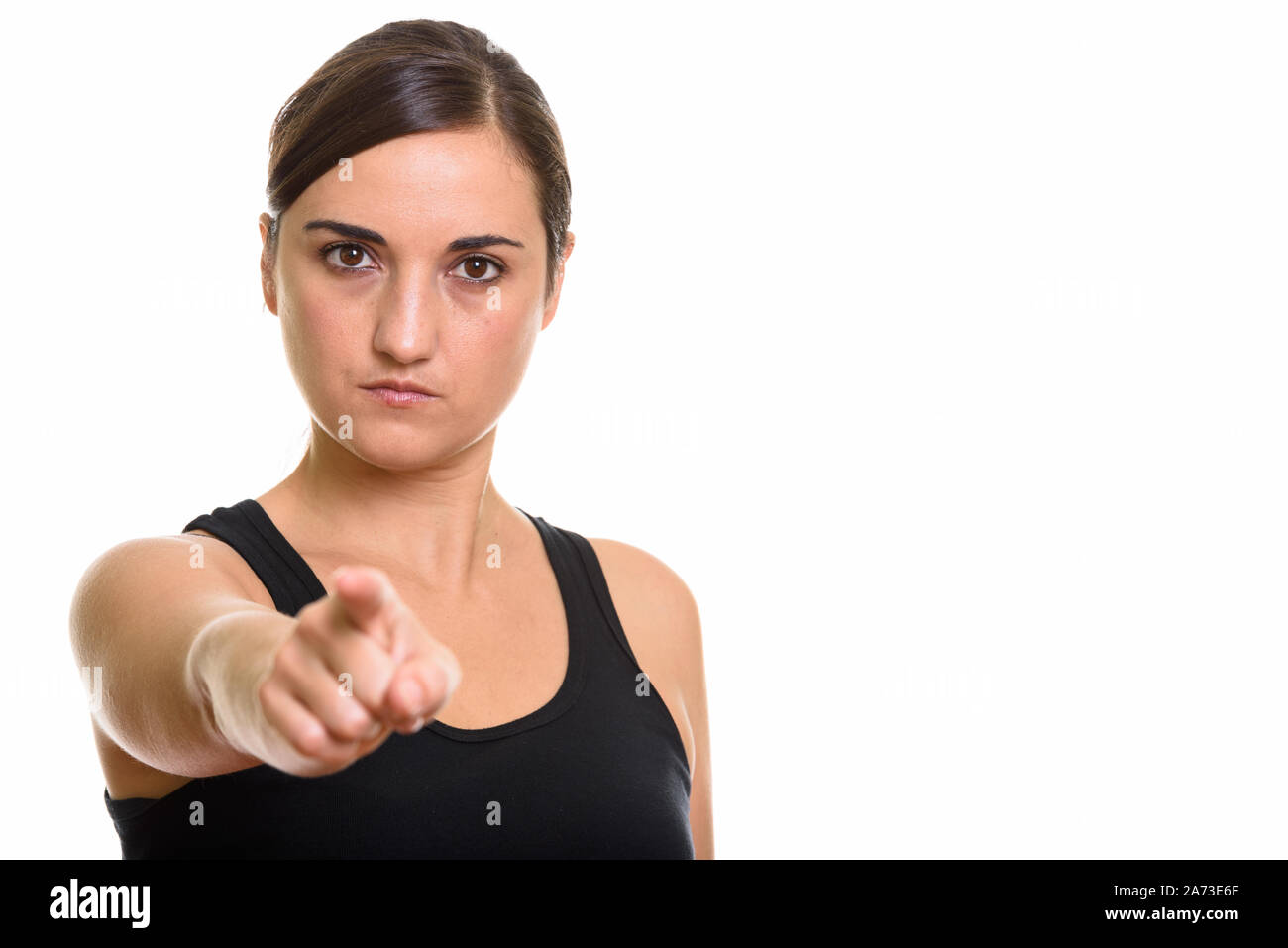 Studio shot of beautiful woman looking angry while pointing at camera ...